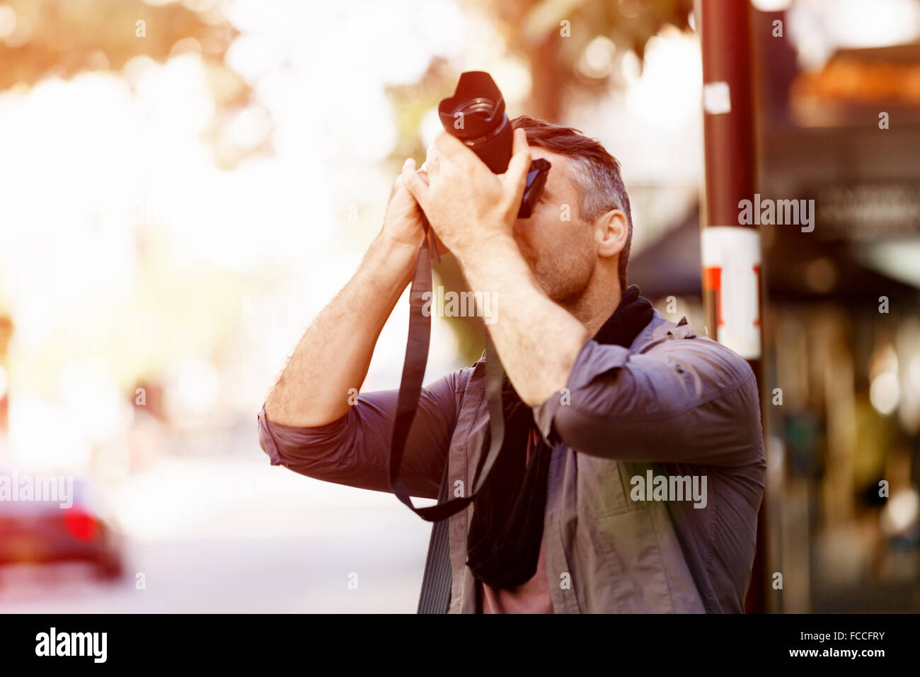 Professional photographer taking picture in city Stock Photo - Alamy