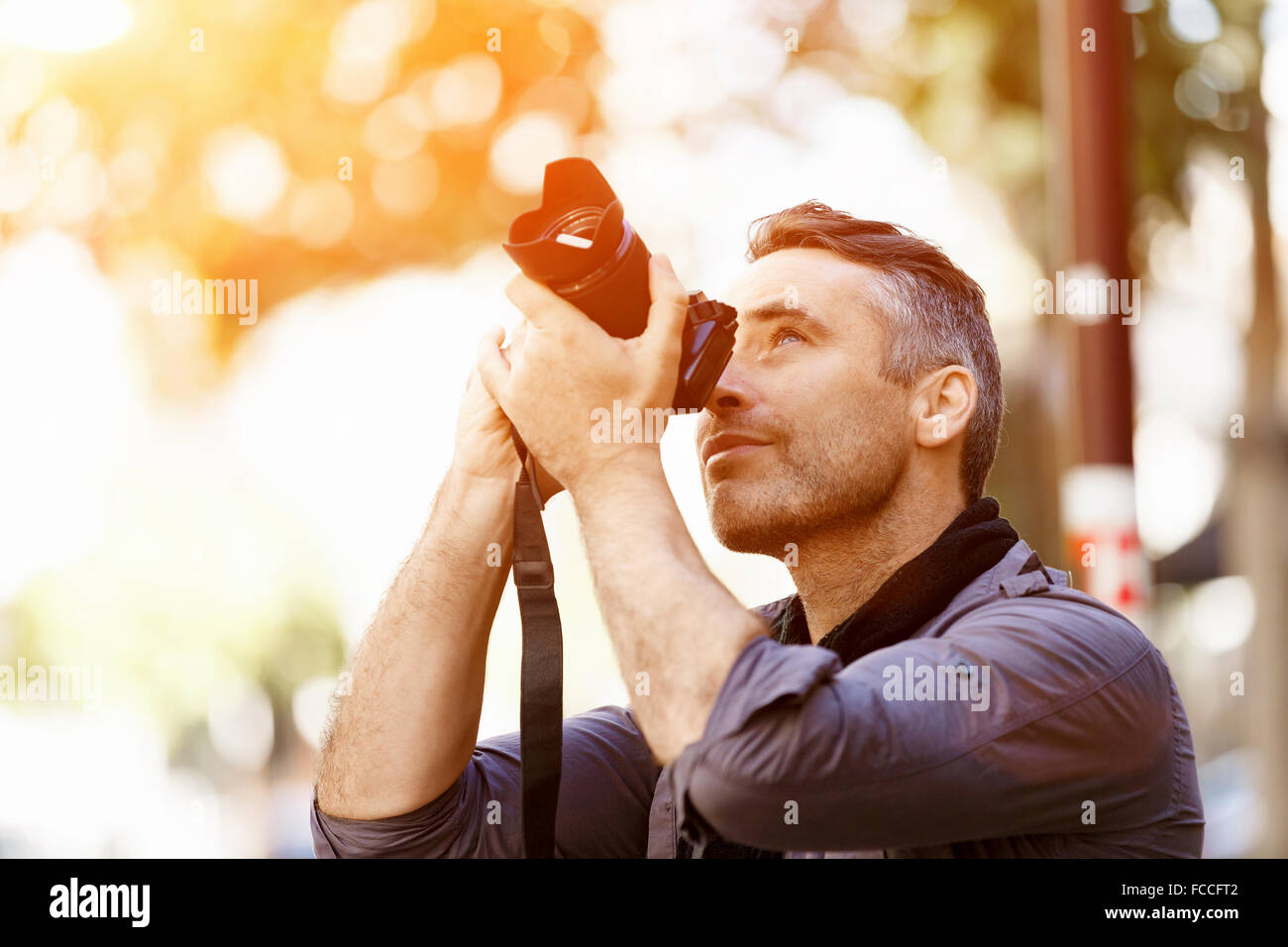 Professional photographer taking picture in city Stock Photo - Alamy