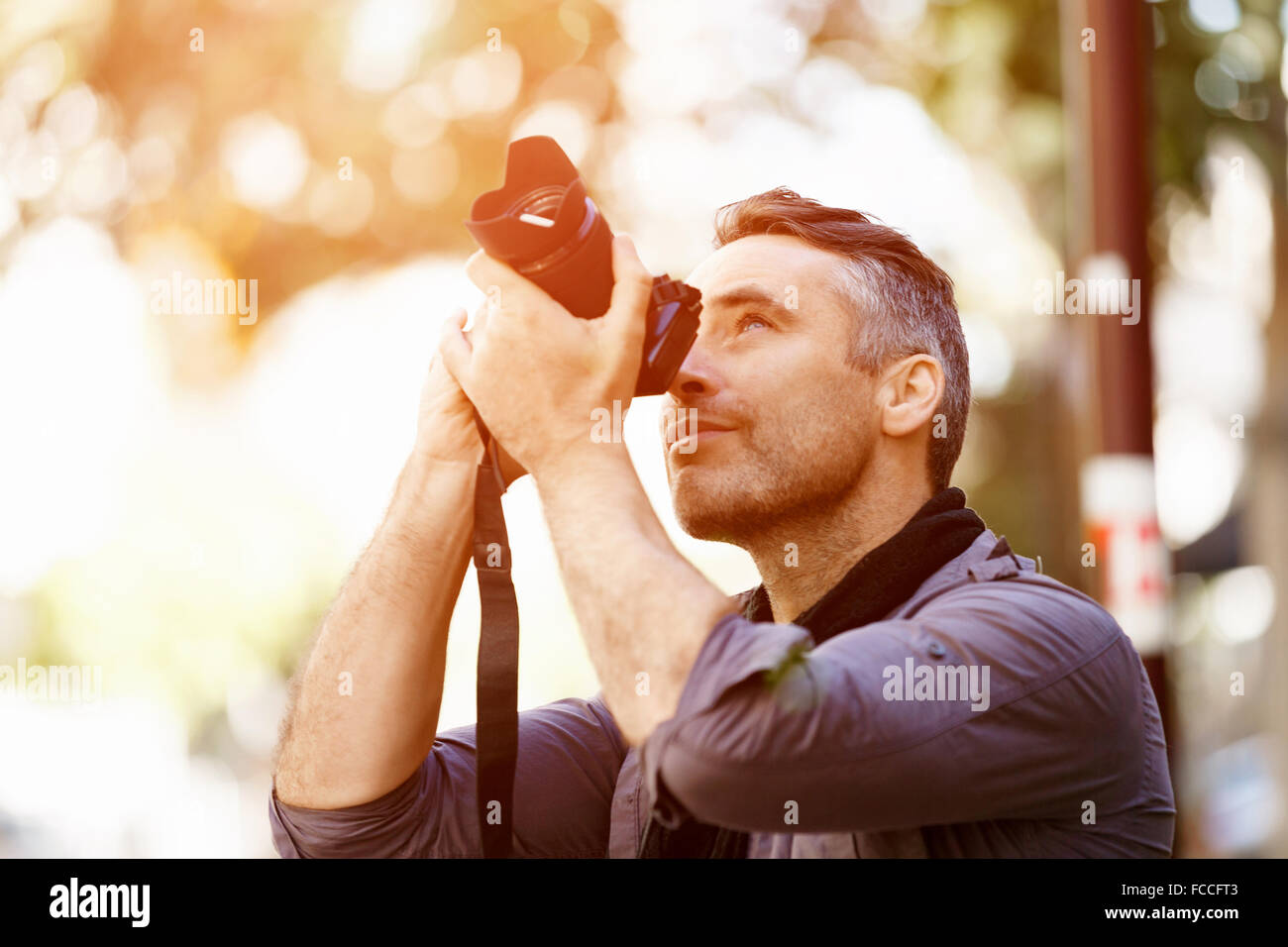 Professional photographer taking picture in city Stock Photo - Alamy