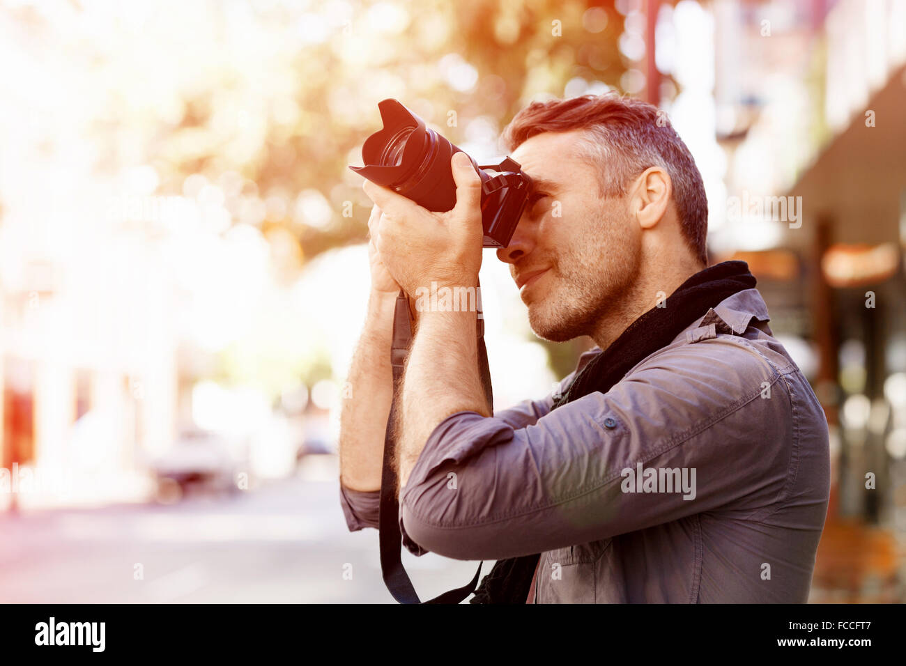 Professional photographer taking picture in city Stock Photo - Alamy