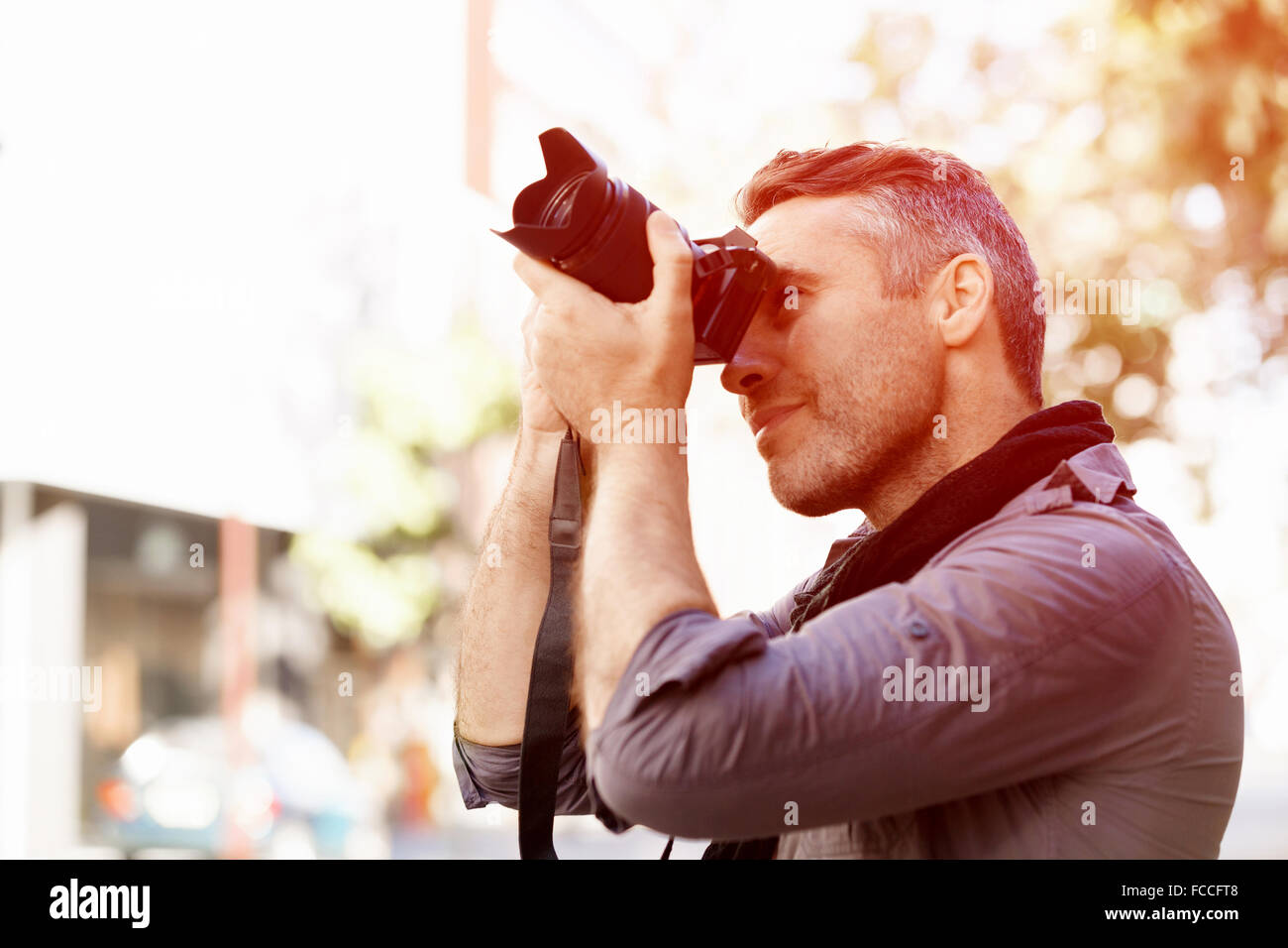 Professional photographer taking picture in city Stock Photo - Alamy