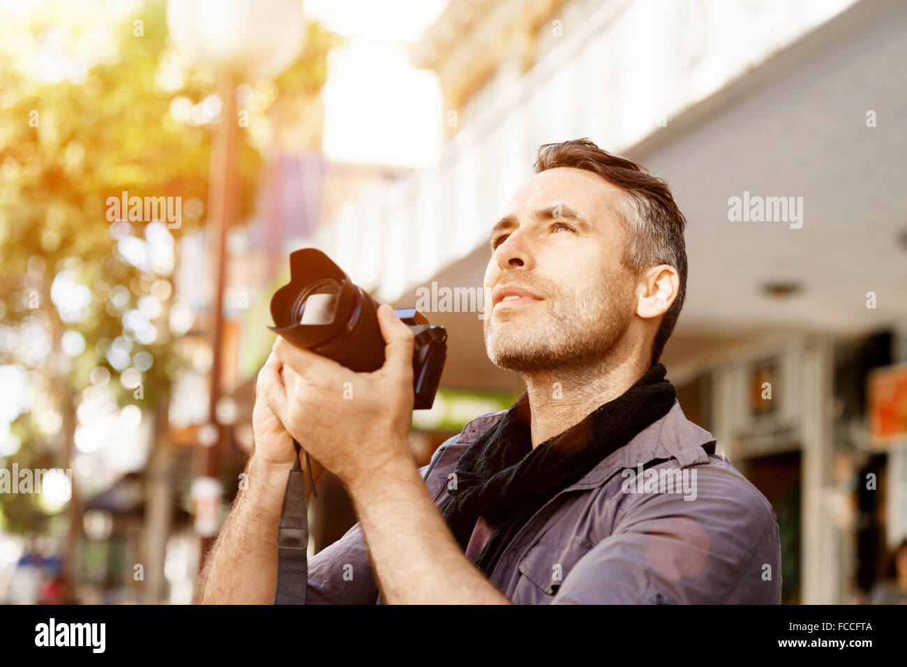 Professional photographer taking picture in city Stock Photo - Alamy
