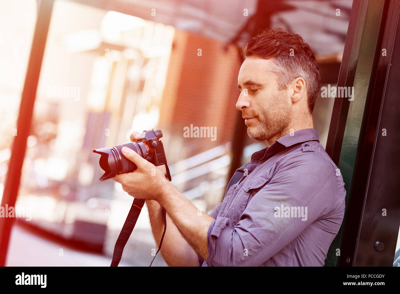 Professional photographer taking picture in city Stock Photo - Alamy