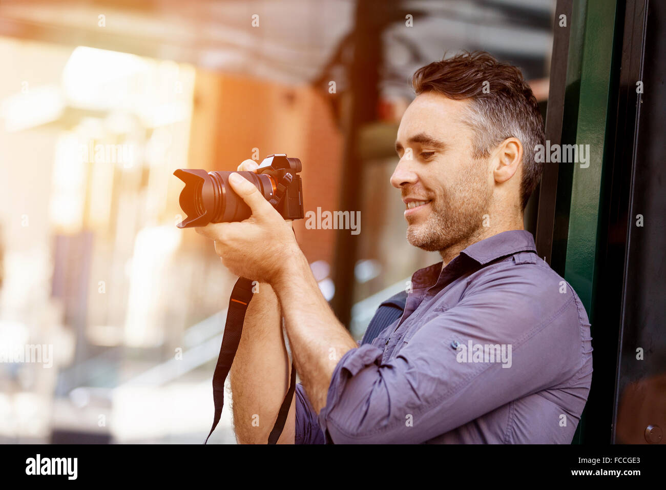 Professional photographer taking picture in city Stock Photo - Alamy