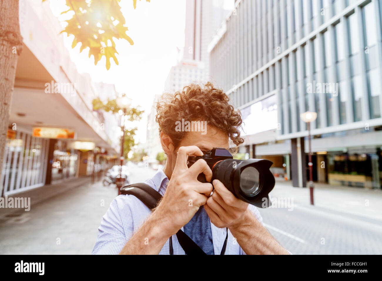 Professional photographer taking picture in city Stock Photo - Alamy