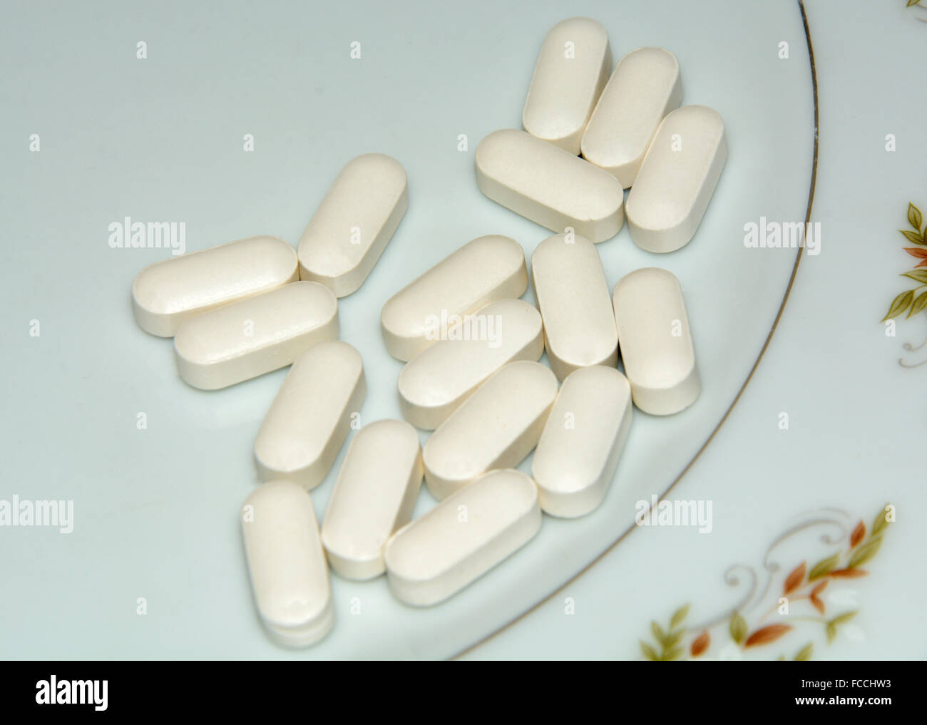 Calcium pills on plate Stock Photo - Alamy