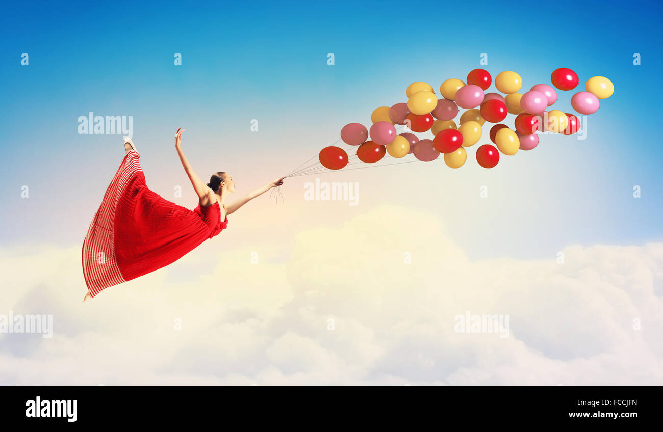 Young woman in dress and ballerinas dancing with colorful balloons ...