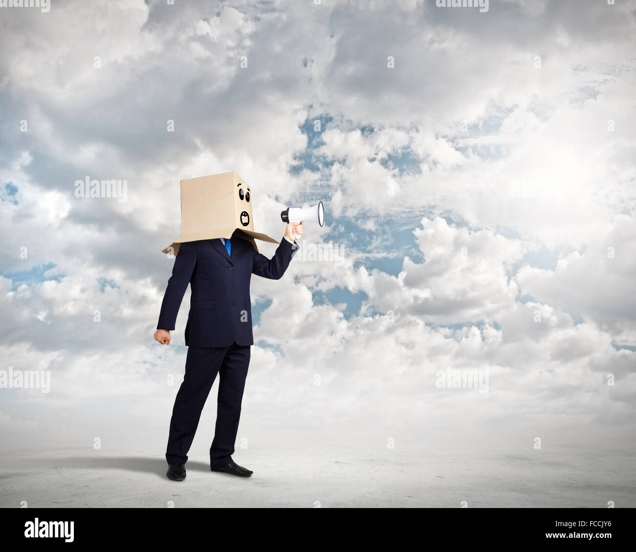 Businessman with box on head screaming in megaphone Stock Photo - Alamy
