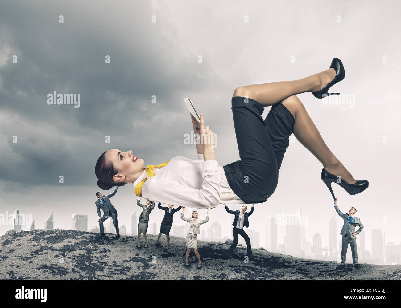 Young businesswoman lying and reading book supported by colleagues ...