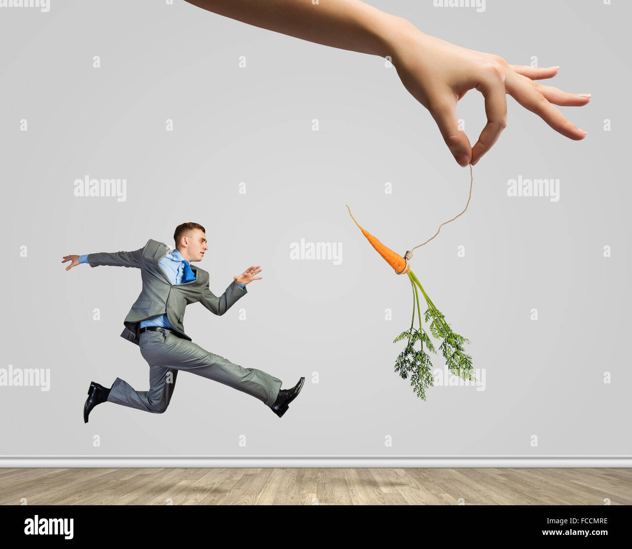 Funny image of businessman chased with carrot Stock Photo - Alamy
