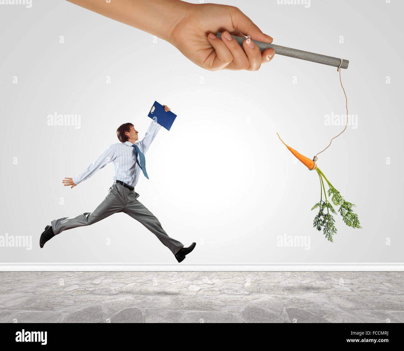 Funny image of businessman chased with carrot Stock Photo - Alamy