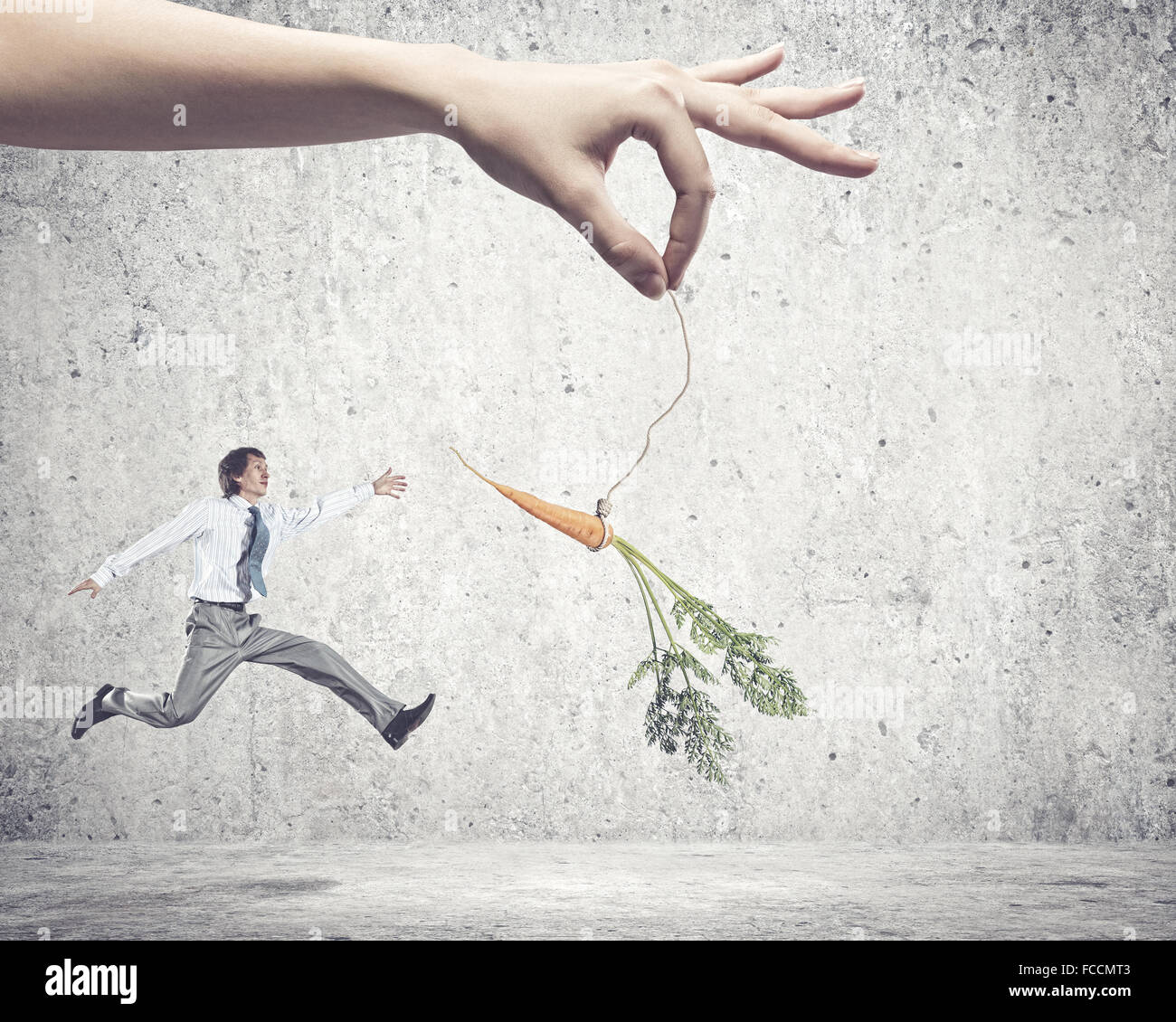 Funny image of businessman chased with carrot Stock Photo - Alamy