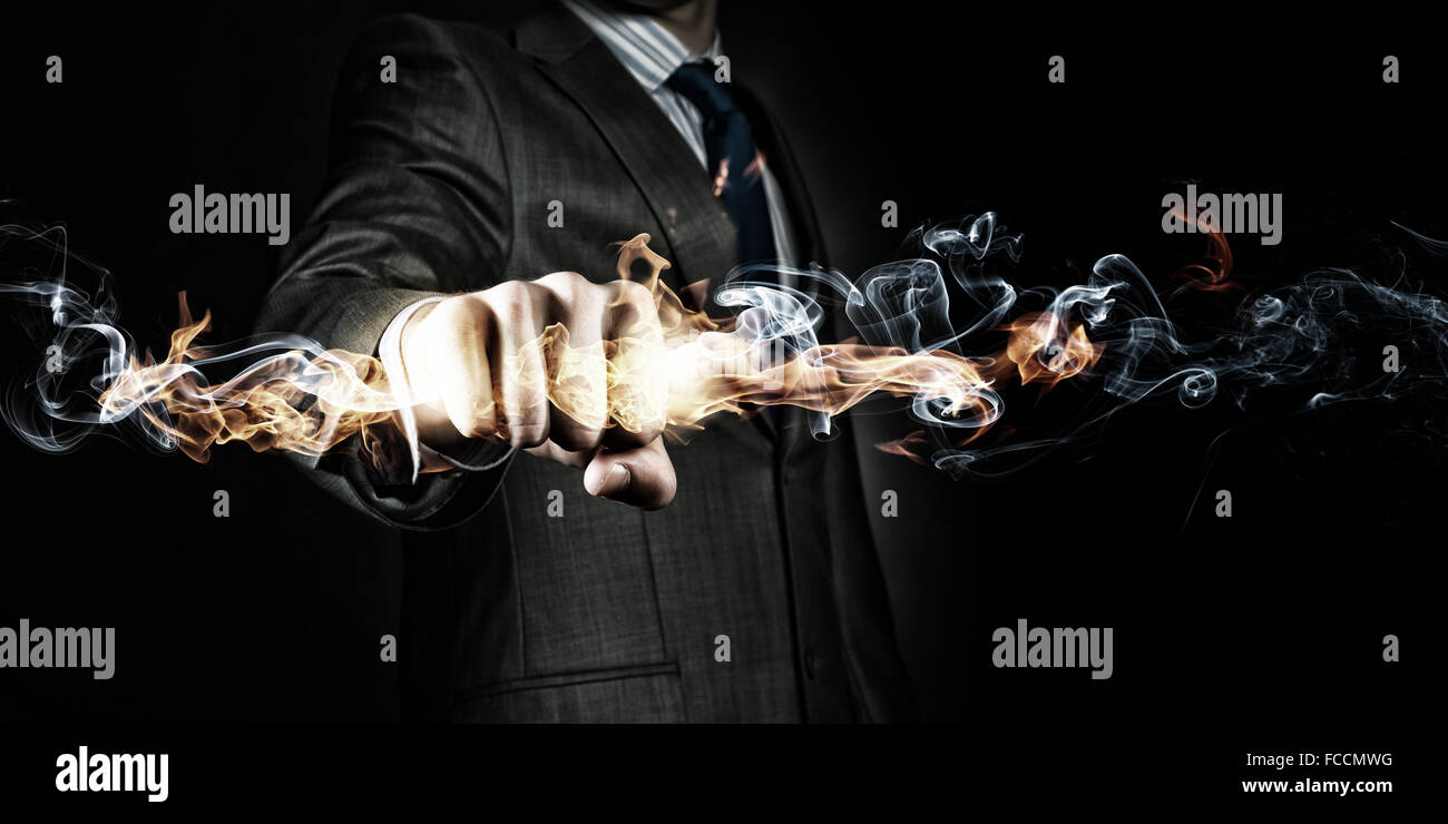 Businessman holding fire flames in fist. Power and control Stock Photo ...