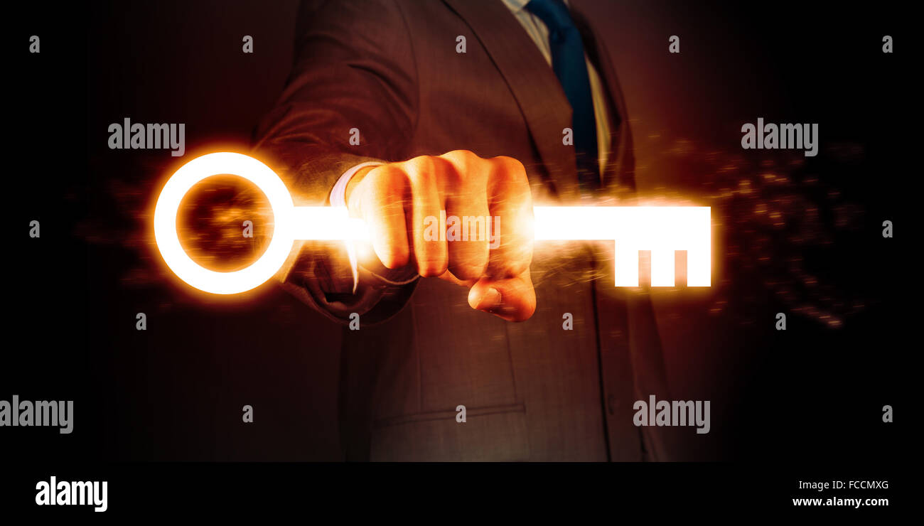 Powerful businessman holding key in his fist Stock Photo - Alamy