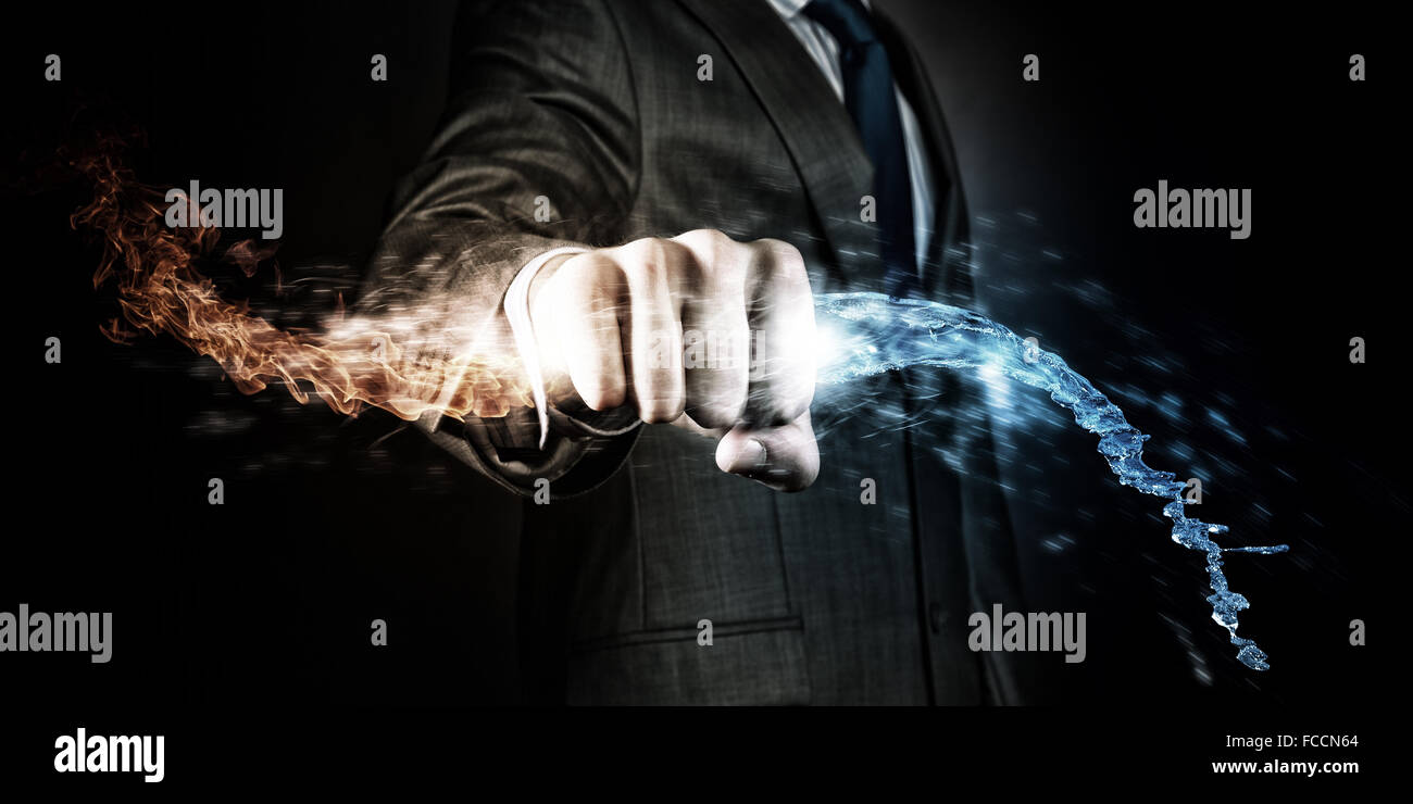 Businessman holding fire flames in fist. Power and control Stock Photo ...