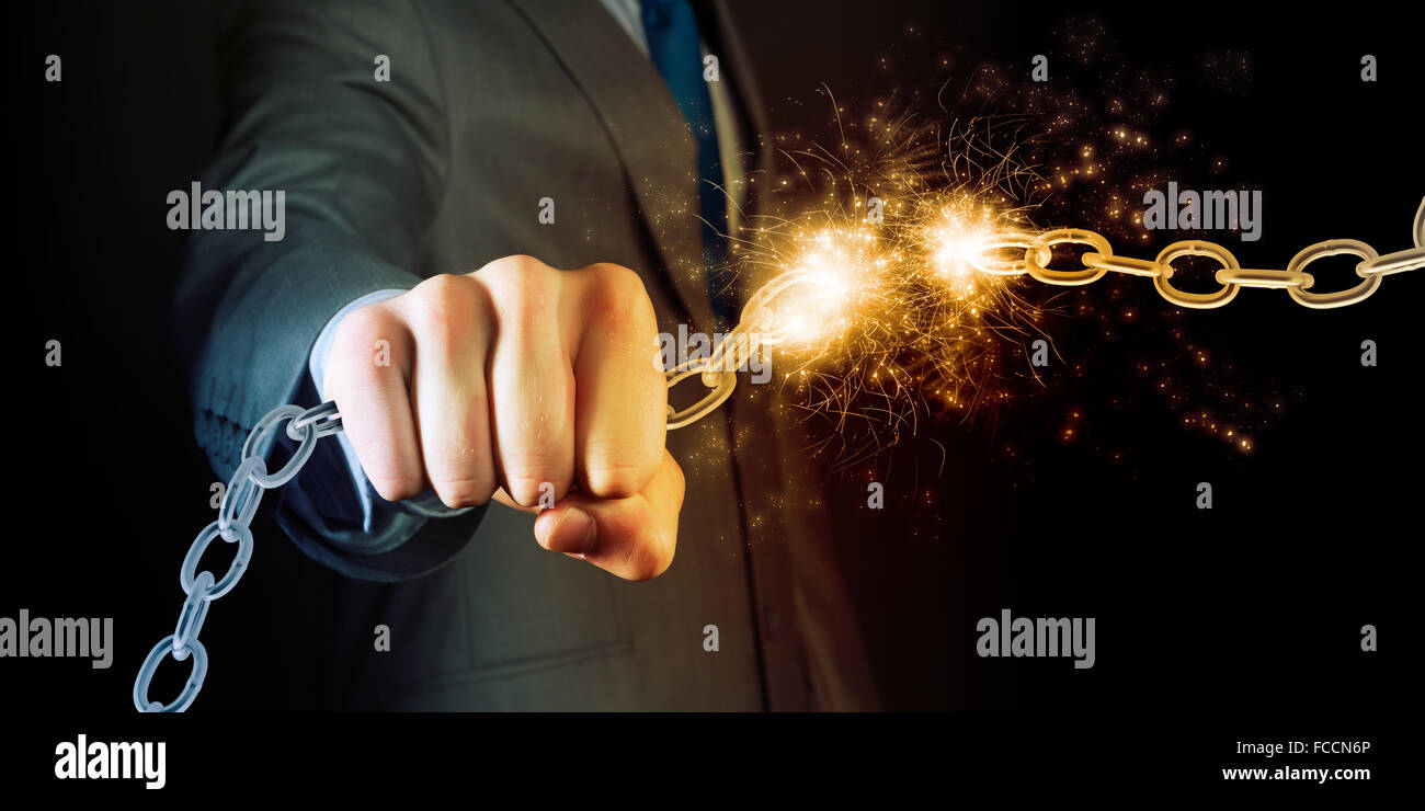 Powerful businessman holding chain in his fist Stock Photo - Alamy