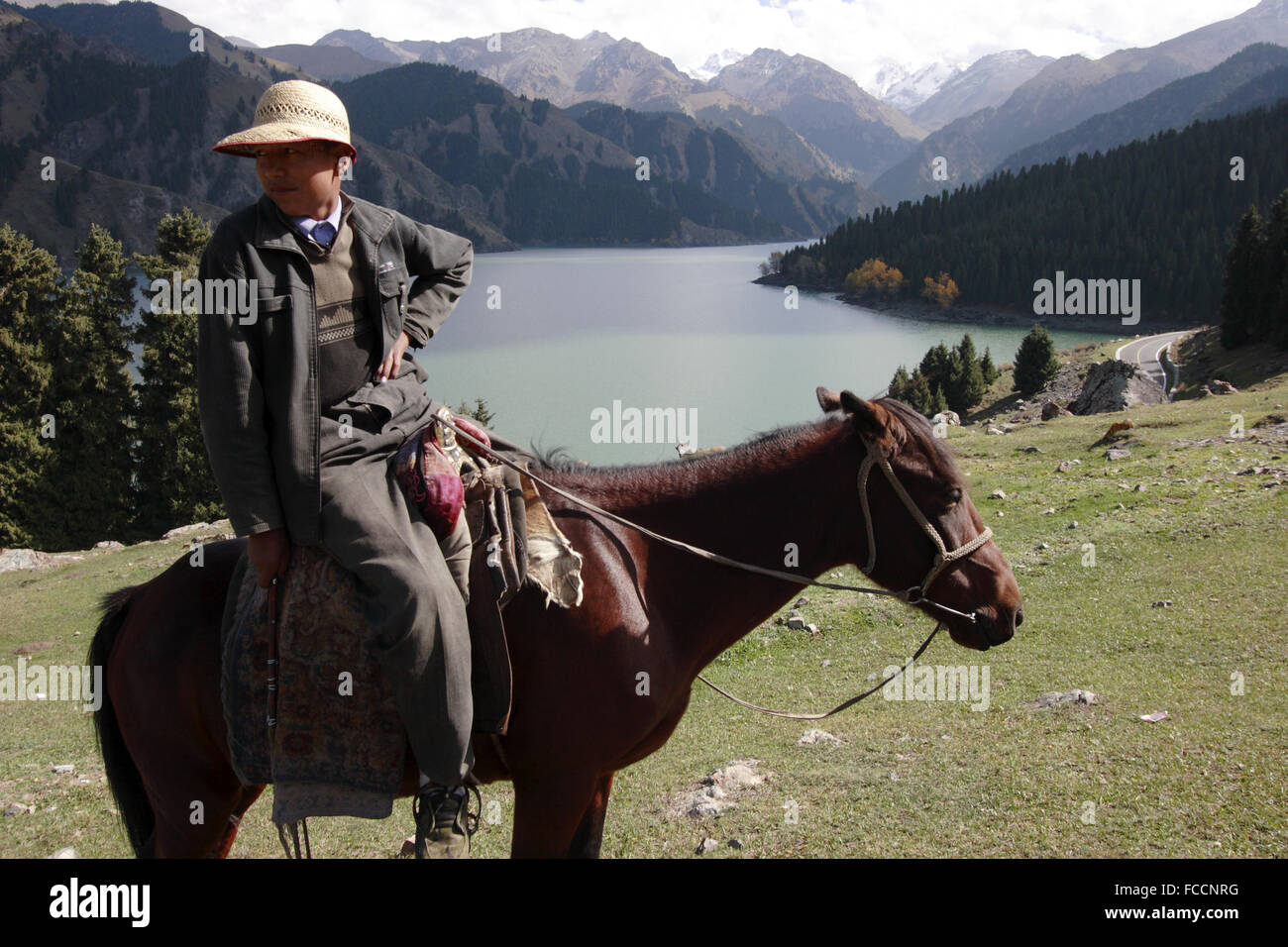 A young Kazakh horseback riding guide in Tianshan Tianchi National Park ...