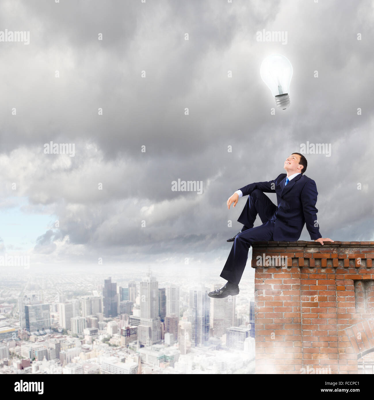 Young successful businessman sitting on top of building Stock Photo - Alamy