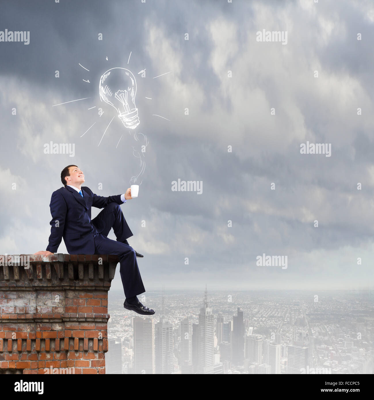 Young successful businessman sitting on top of building Stock Photo - Alamy