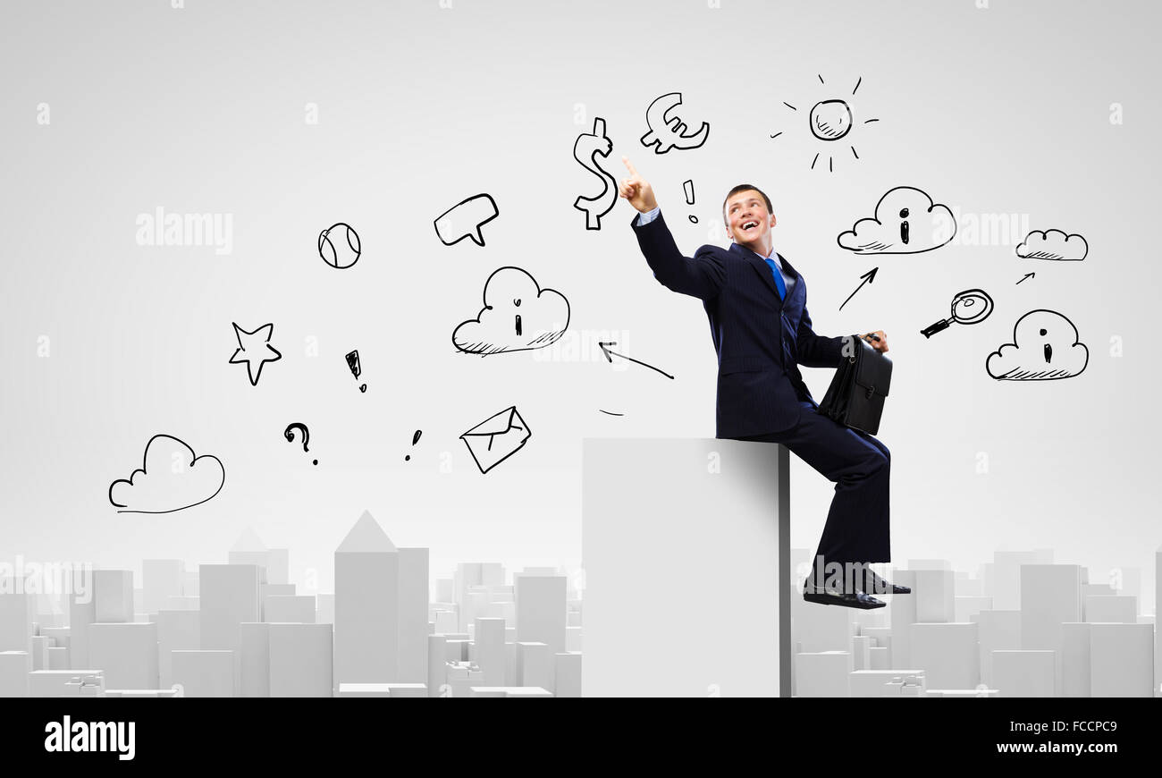 Young successful businessman sitting on top of building Stock Photo - Alamy
