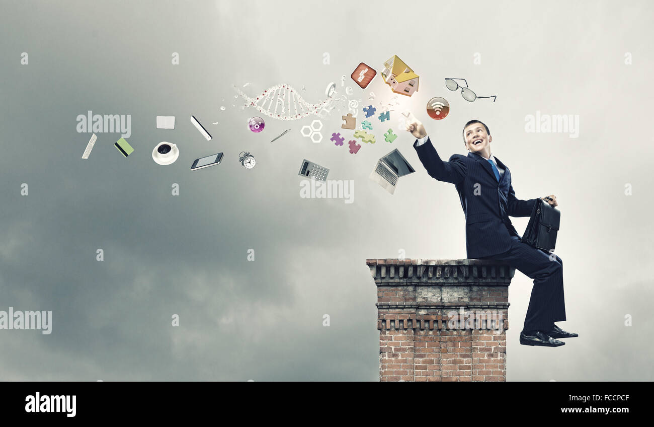 Young successful businessman sitting on top of building Stock Photo - Alamy