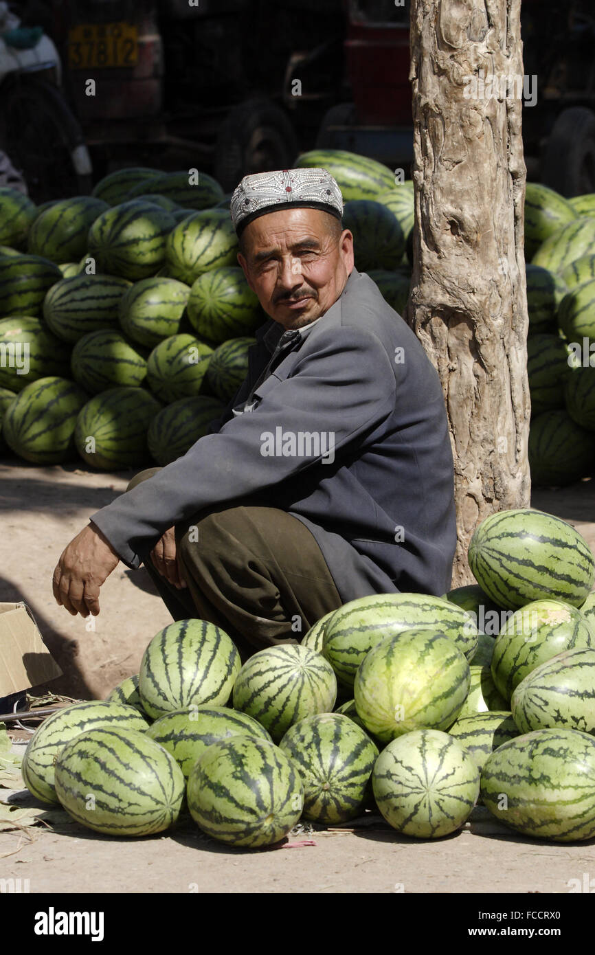 A Uyghur man selling watermelons in traditional Sunday Market in ...