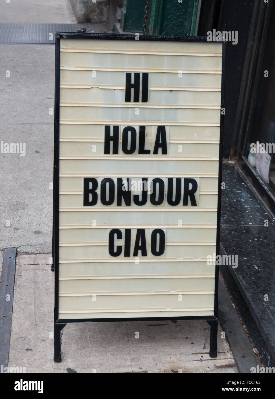 A-board sign outside a store with "hi" - English, "hola"- Spanish ...