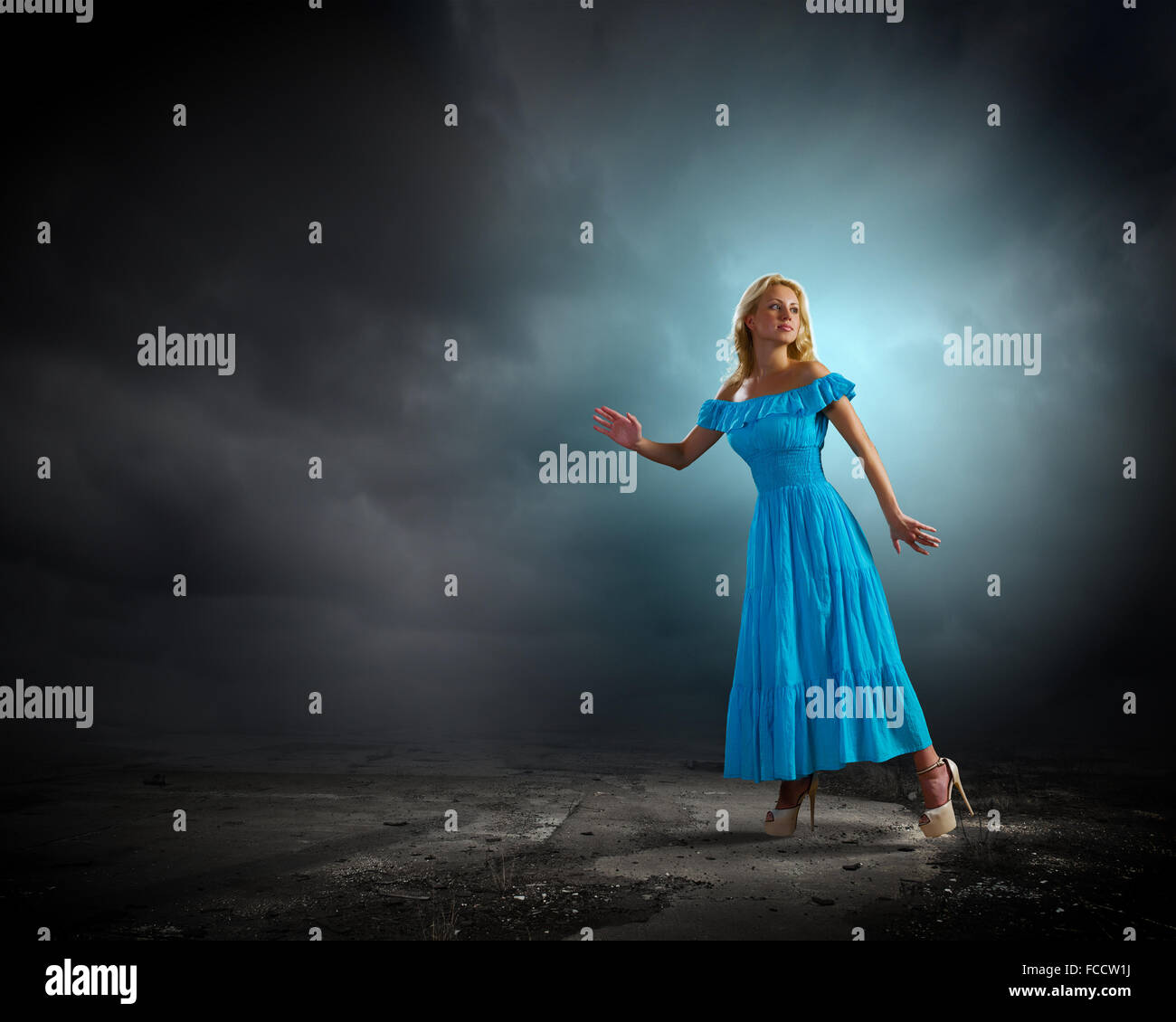 Anxious young woman in blue dress looking back worried Stock Photo - Alamy