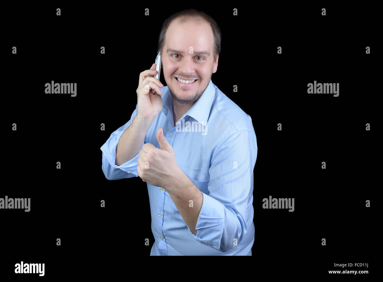 young man smiling talking mobile phone thumbs up Stock Photo - Alamy