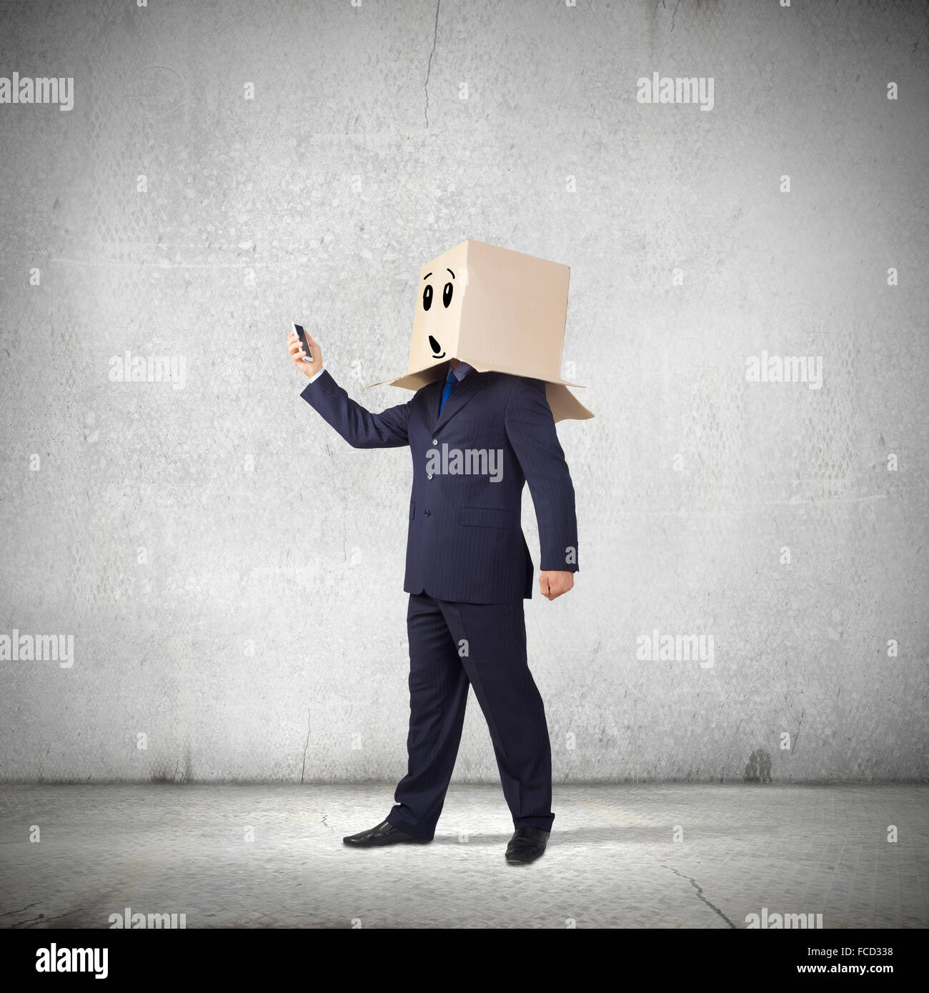 Businessman using mobile phone wearing carton box on head Stock Photo ...