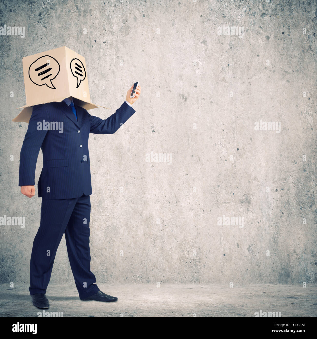 Businessman using mobile phone wearing carton box on head Stock Photo ...