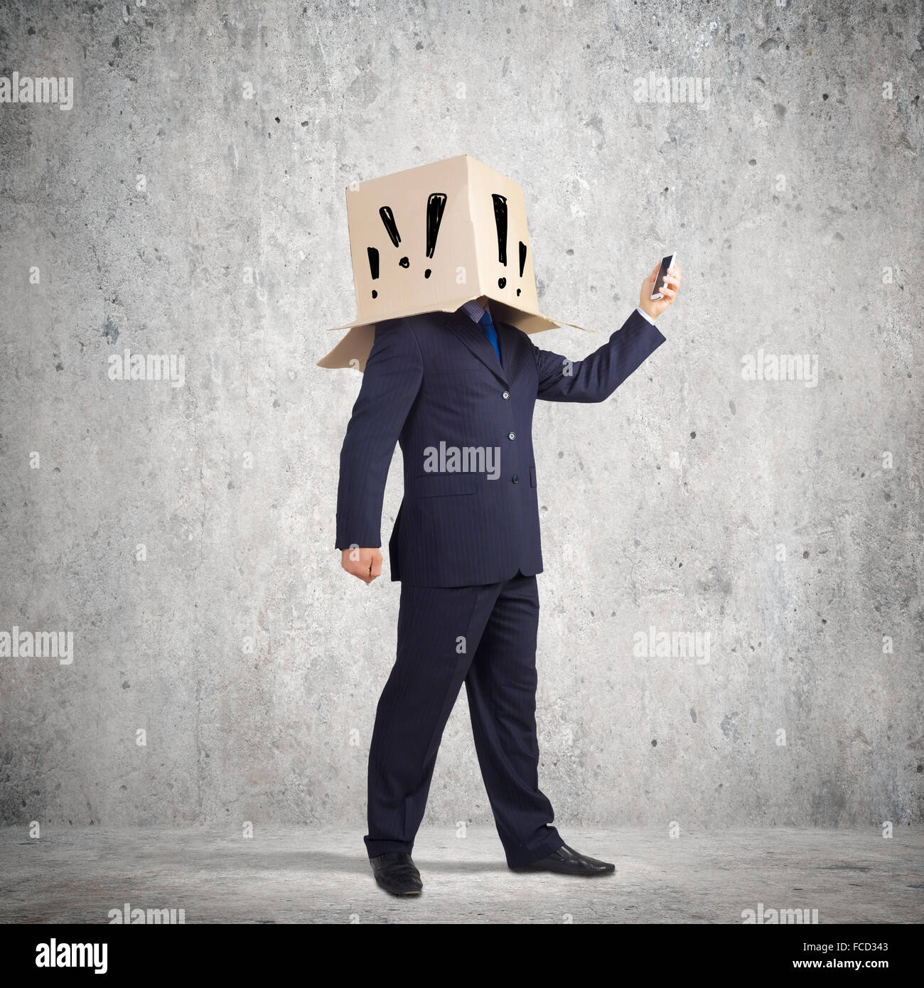 Businessman using mobile phone wearing carton box on head Stock Photo ...