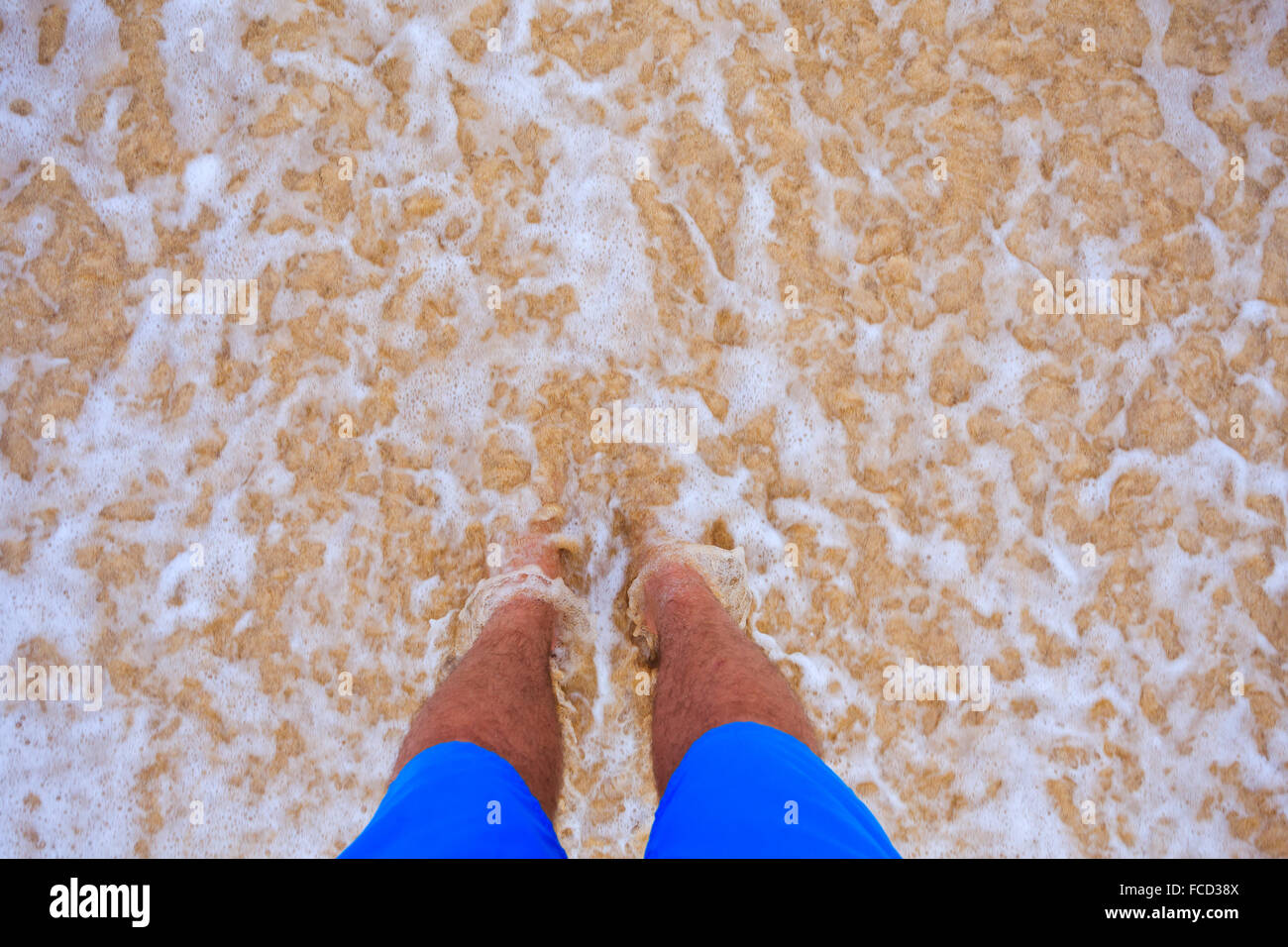 Feet on the beach as the waves come in and out in Oahu Hawaii on the ...