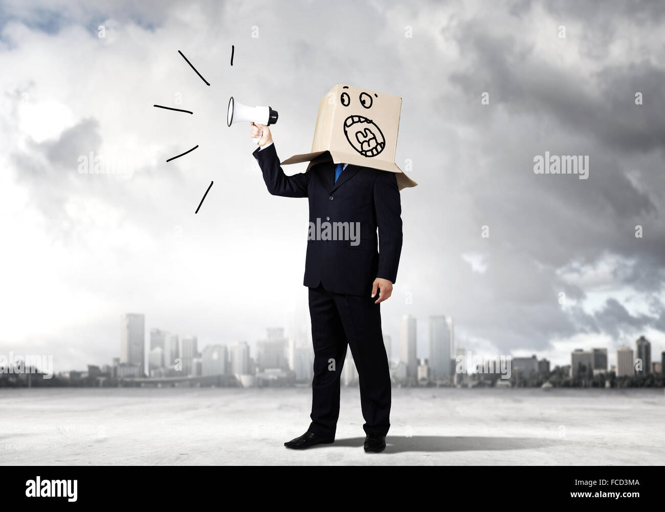 Businessman wearing carton box on head and screaming in to megaphone ...