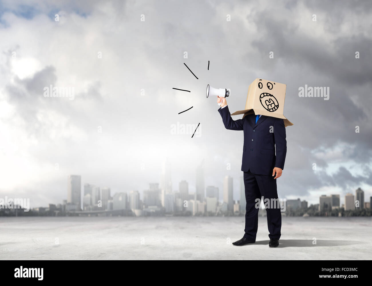 Businessman wearing carton box on head and screaming in to megaphone ...