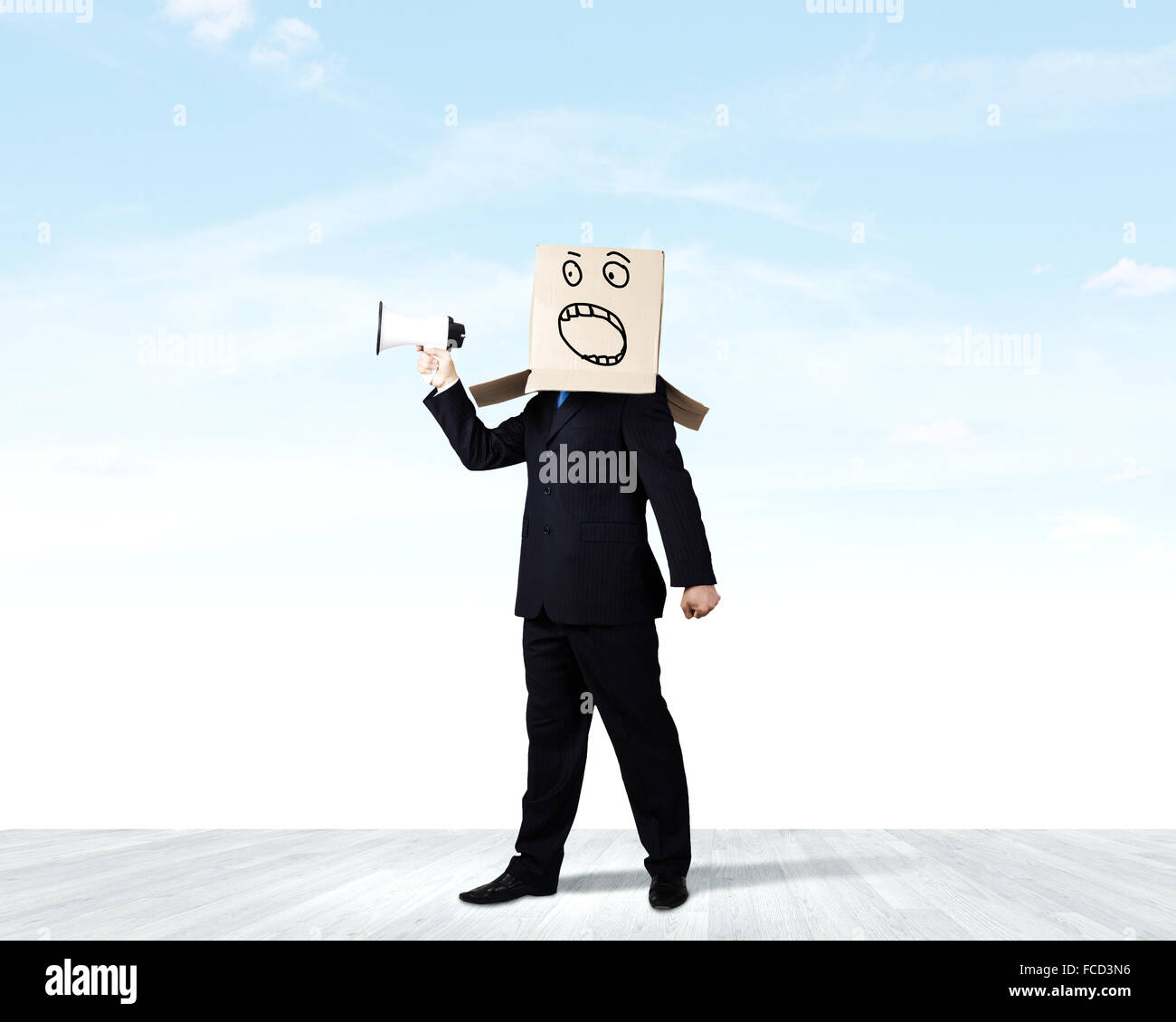 Businessman wearing carton box on head and screaming in to megaphone ...