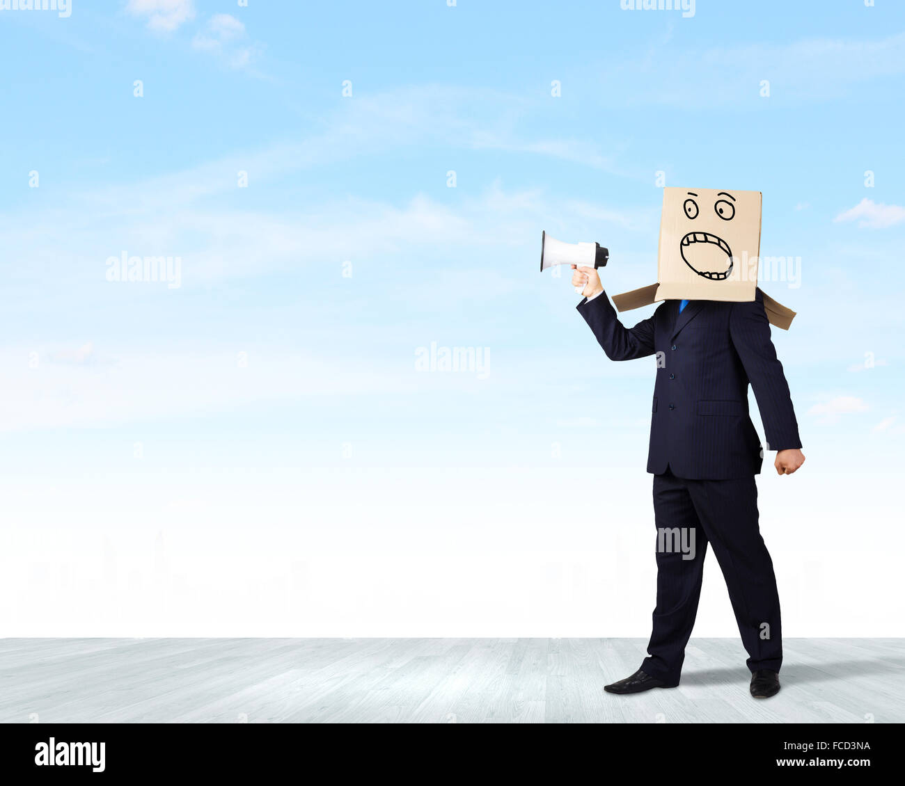 Businessman wearing carton box on head and screaming in to megaphone ...