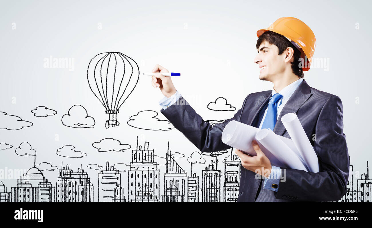 Young man engineer in helmet drawing construction project Stock Photo ...