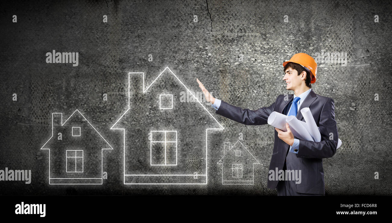 Young man engineer in helmet drawing construction project Stock Photo ...
