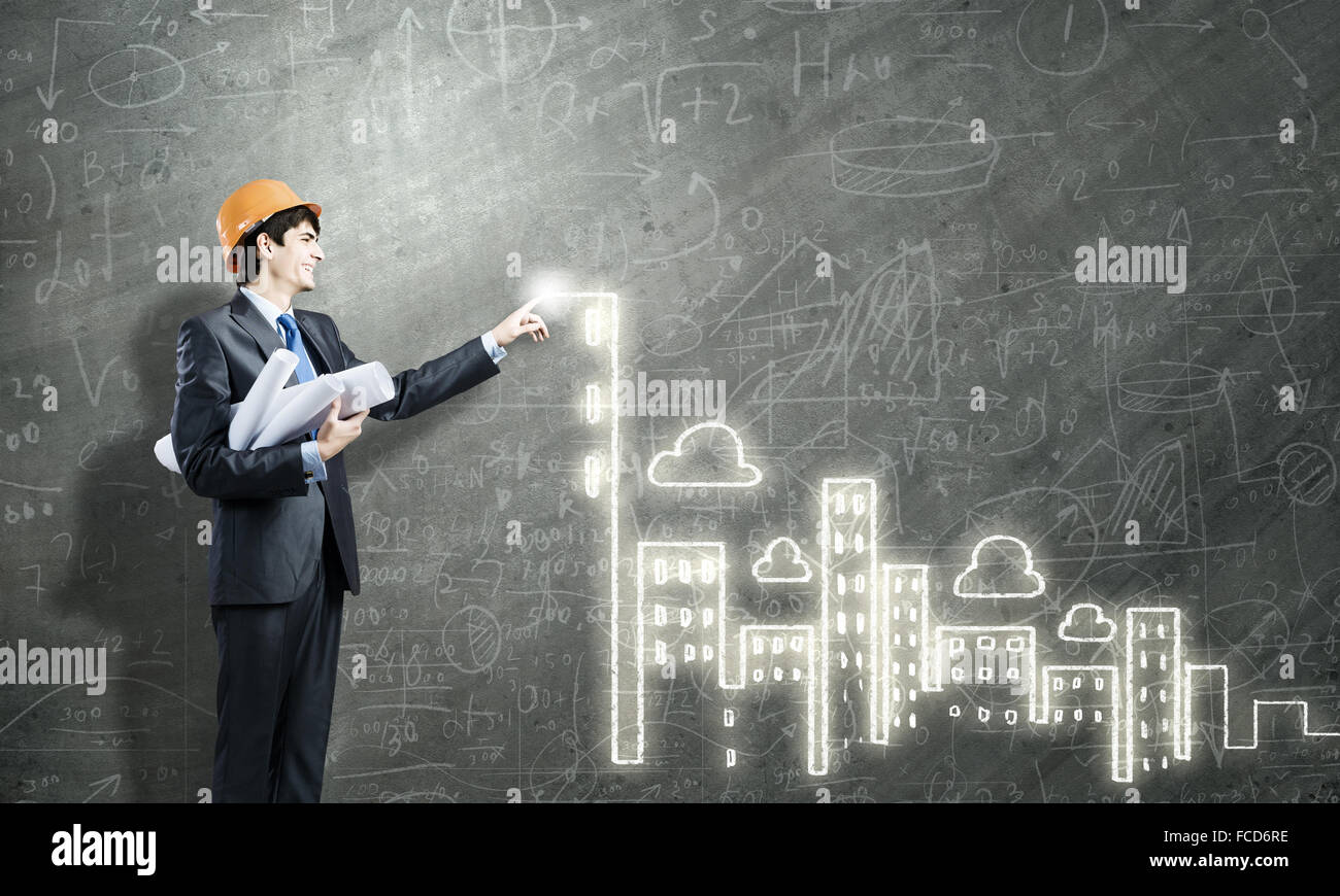 Young man engineer in helmet drawing construction project Stock Photo ...