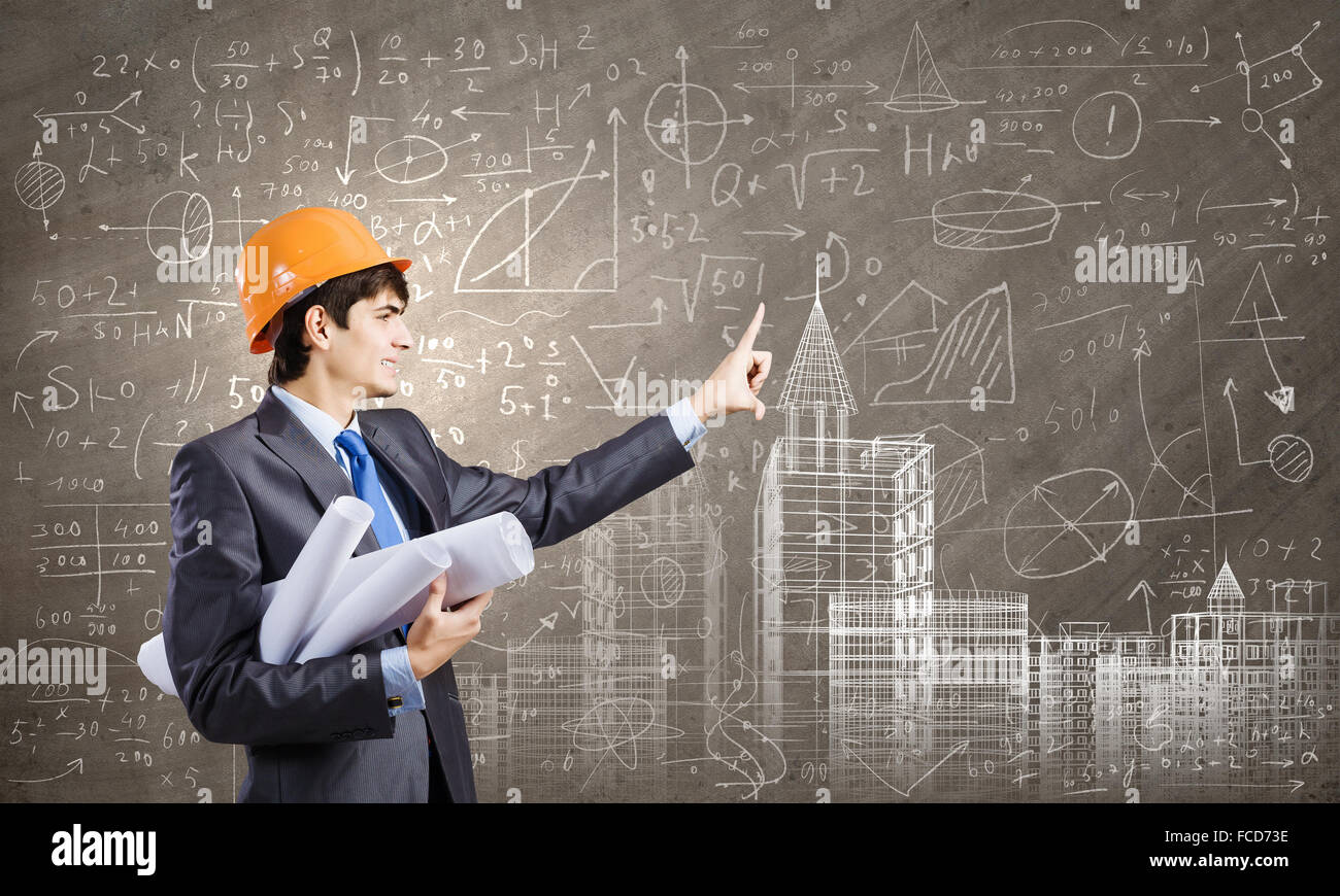 Young man engineer in helmet against construction project Stock Photo ...
