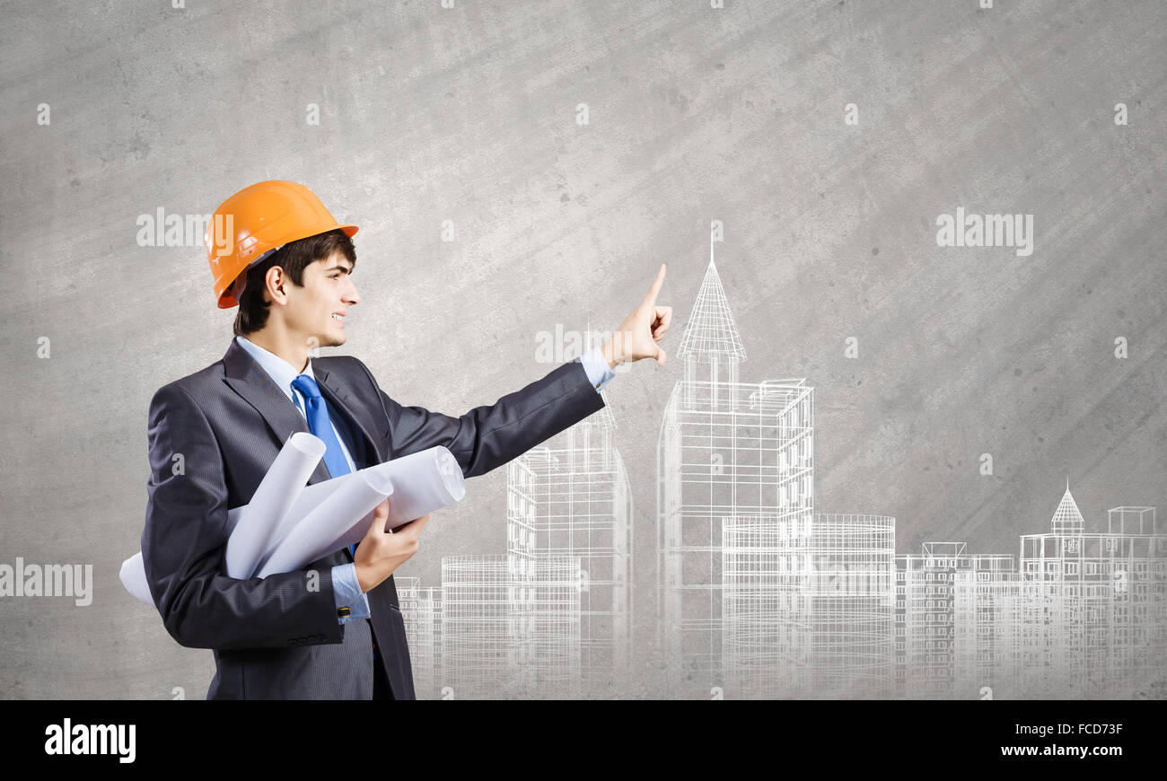 Young man engineer in helmet against construction project Stock Photo ...