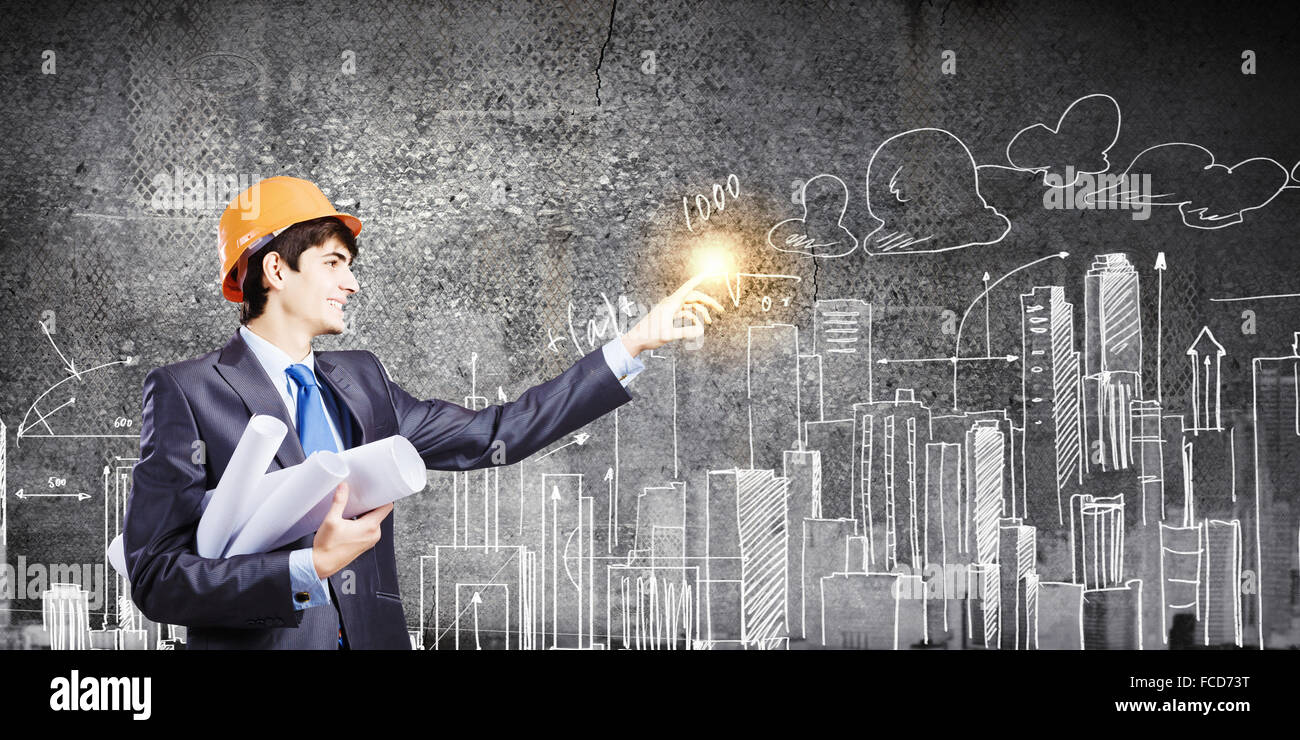 Young man engineer in helmet drawing construction project Stock Photo ...