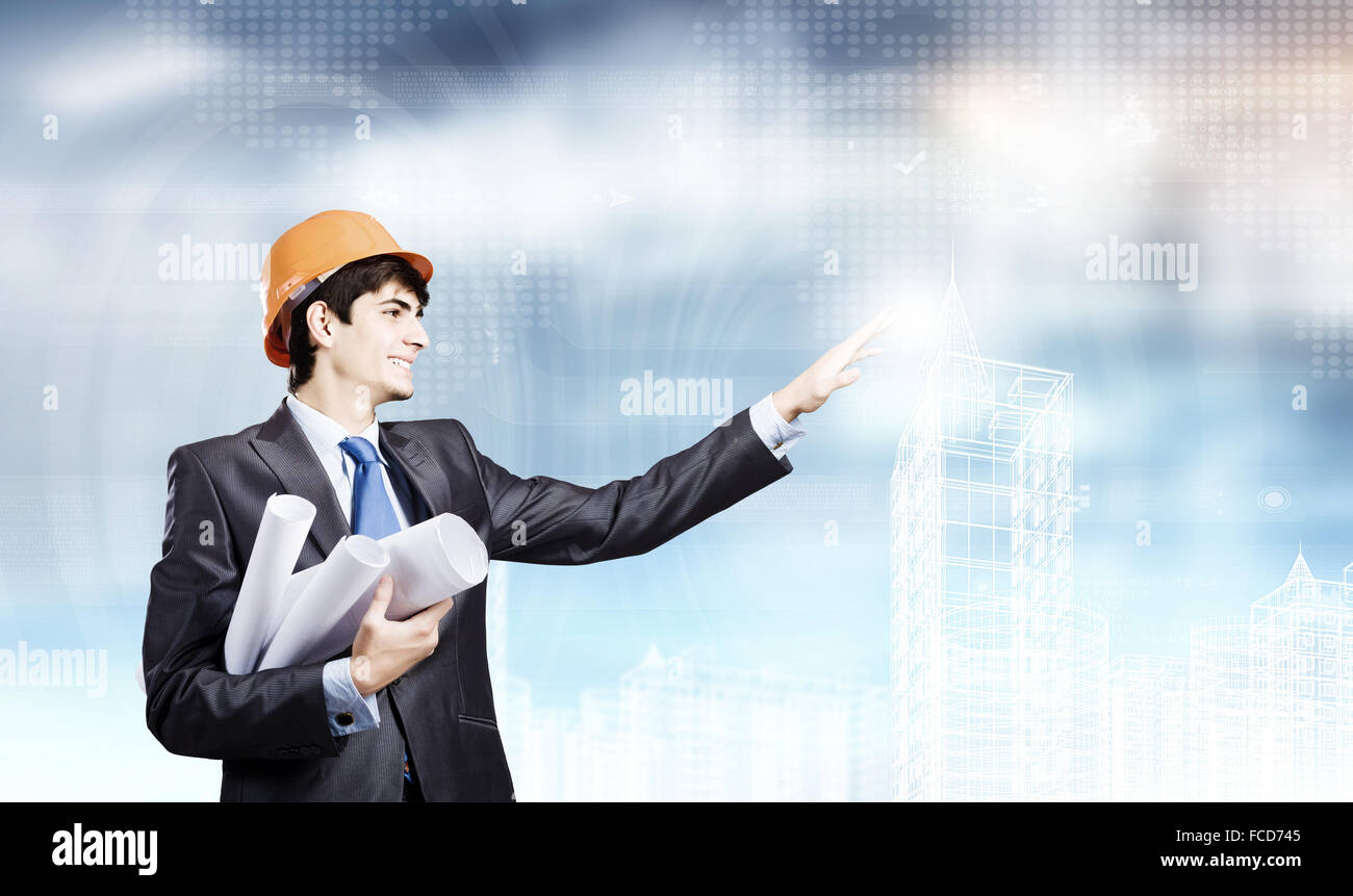 Young man engineer in helmet touching icon of media screen Stock Photo ...