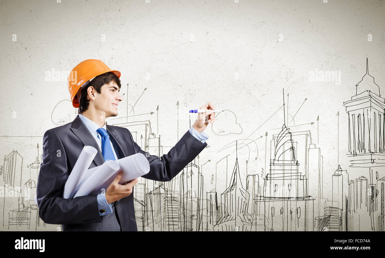 Young man engineer in helmet drawing construction project Stock Photo ...