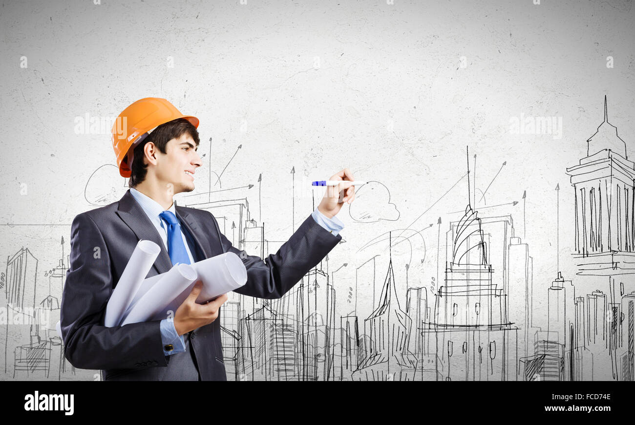 Young man engineer in helmet drawing construction project Stock Photo ...