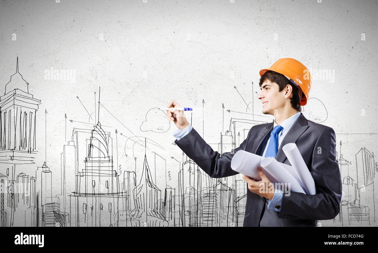 Young man engineer in helmet drawing construction project Stock Photo ...
