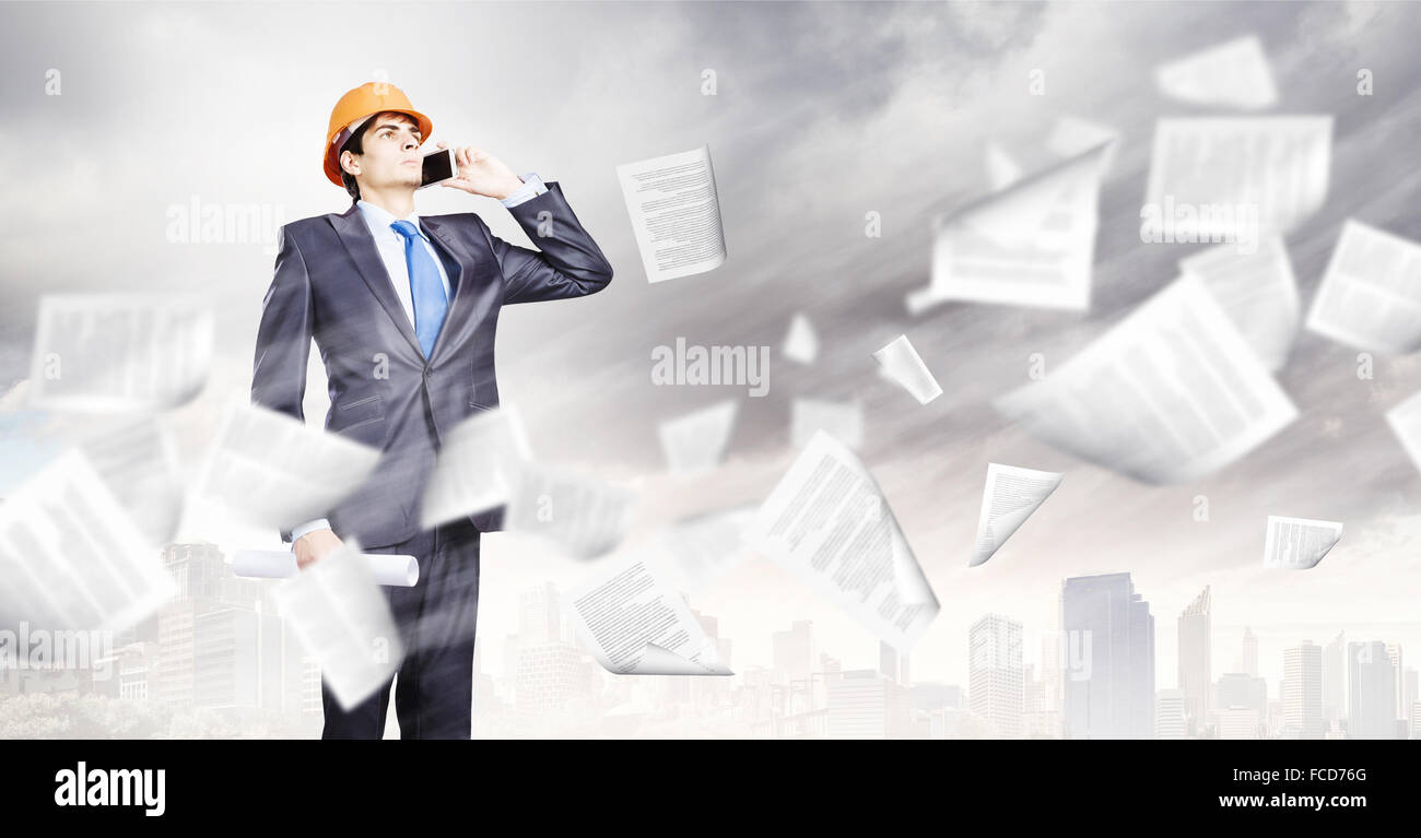 Young man engineer in helmet talking on mobile phone Stock Photo - Alamy