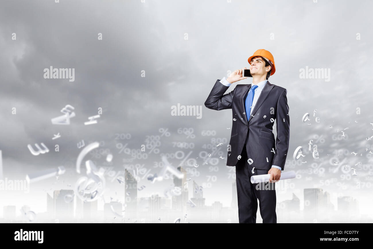 Young man engineer in helmet talking on mobile phone Stock Photo - Alamy