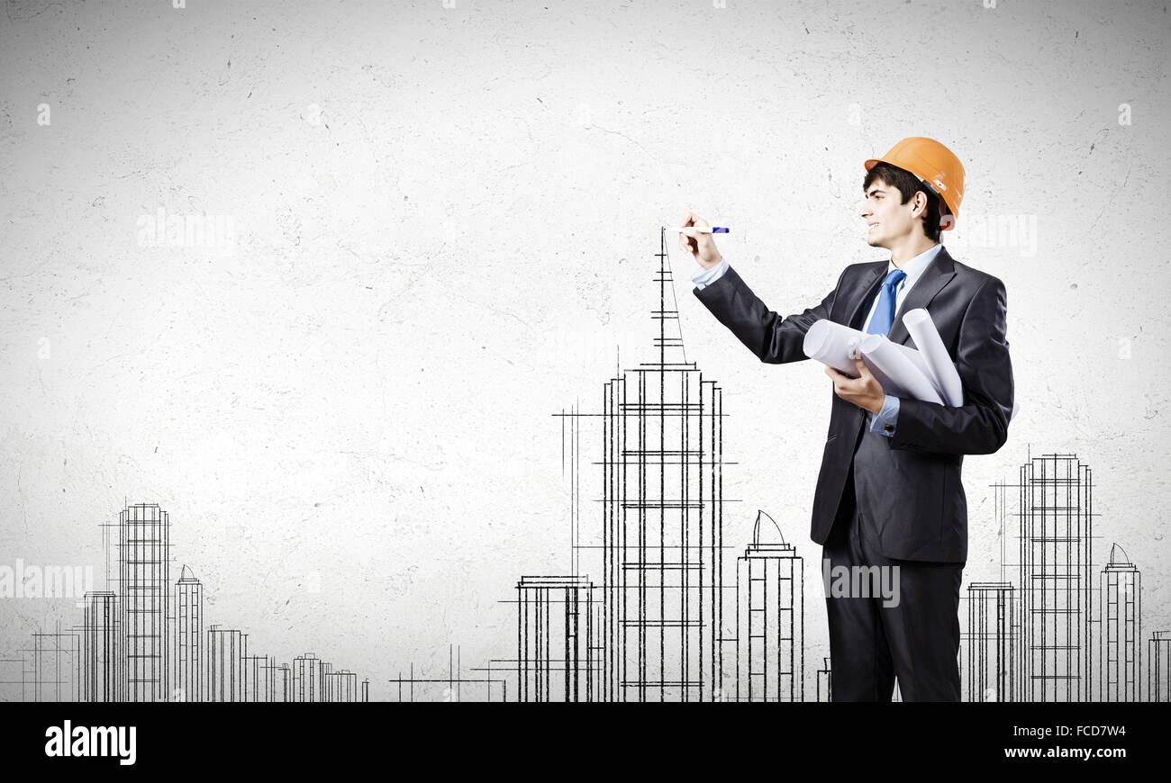 Young man engineer in helmet drawing construction project Stock Photo ...